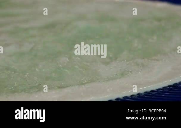 Water churns violently in jacuzzi, bubbles erupting and collapsing in ...