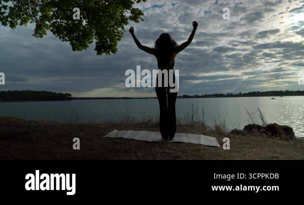 Enjoying a peaceful yoga session beside the tranquil lakeside, fully ...