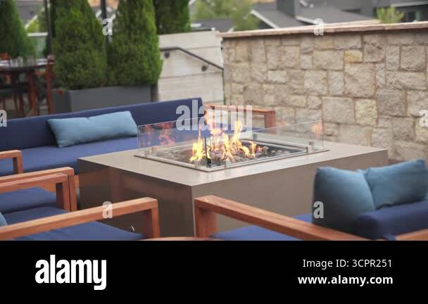 Stylish outdoor lounge features a contemporary fire pit surrounded by ...