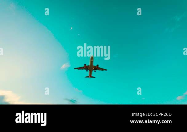 Airliner flying overhead in bright sky with scattered clouds creating ...