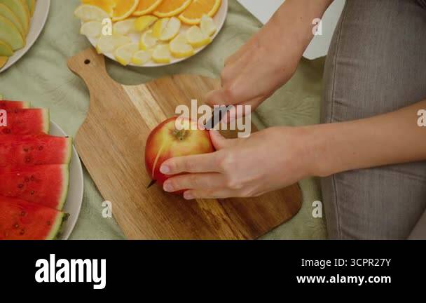 Cutting apple on cutting board with knife. Preparing apple slices for ...