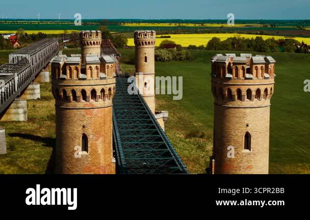 Railway bridge passing between medieval style brick towers surrounded ...