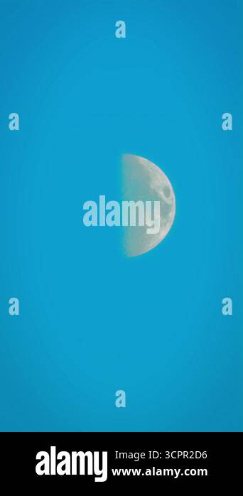 Moon appearing in daylight sky with half surface illuminated. Lunar ...