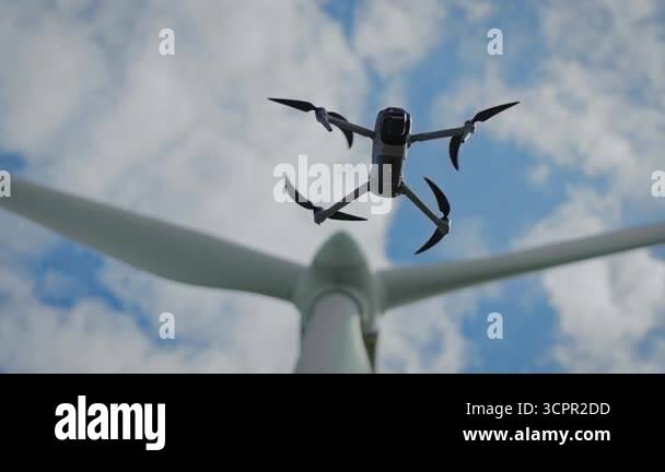 Flying drone capturing wind turbine operation close-up. Hovering aerial ...