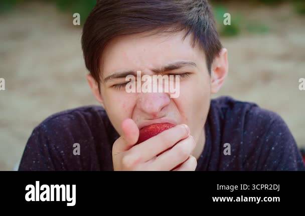 Boy teenager eating red apple, savoring juicy and tangy flavor with ...