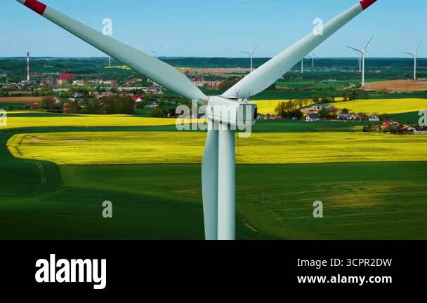 Wind turbine producing green electricity near rural town close-up. Wind ...