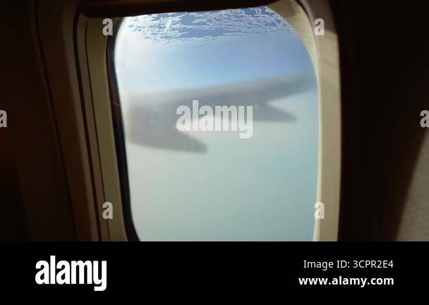 Hand of unrecognizable woman closing window shade in airplane during ...