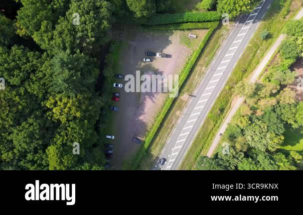 Aerial view of a parking lot beside a multi-lane road with pedestrian ...