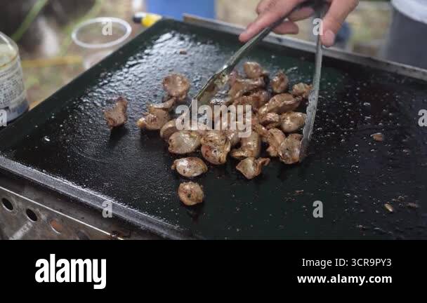 Grilling gizzards on an iron plate Stock Video Footage - Alamy
