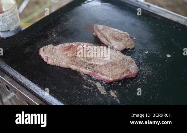 Grilling beef on an iron plate Stock Video Footage - Alamy