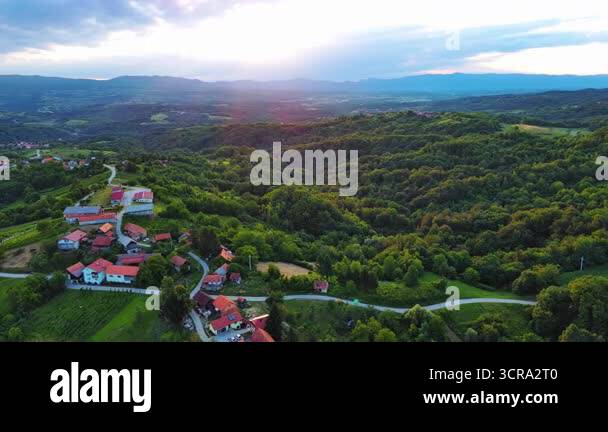 A small cozy village with cute houses and paved roads in a valley with ...