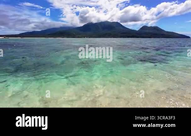 View overlooking blue clear tropical waters and volcanic island ...