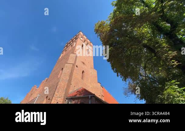 Video of a tall medieval gothic brick tower captured from a low angle ...