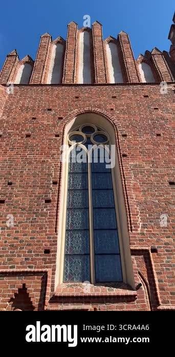 Vertical video showing a gothic church facade with tall stained glass ...