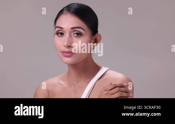 A pretty woman looks confidently at the camera and her soft hair framing her elegant features ...