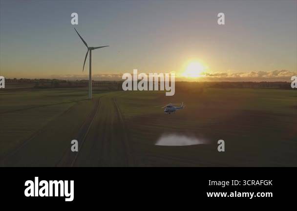 Animated helicopter landing by a large wind turbine at sunset Stock ...