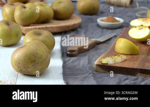 A half-cut apple and a small wedge, both lightly dusted with cinnamon ...