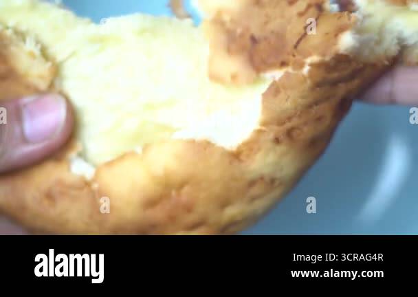 Hands tearing apart cheese-flavored bread from the top view perspective ...