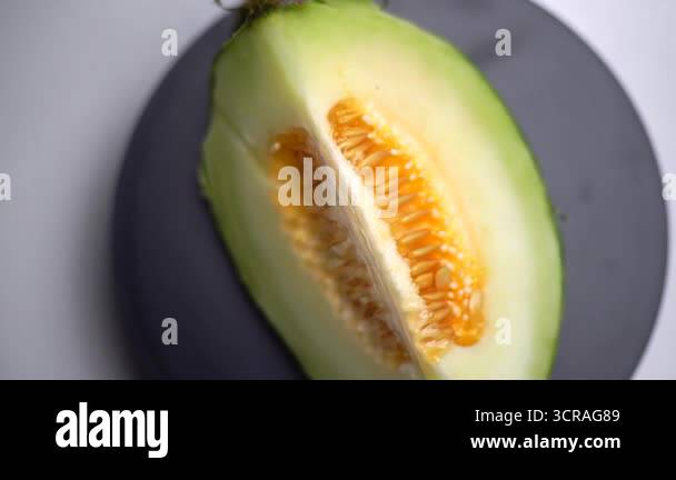 A quarter slice of melon filled with seeds is rotating, captured from a ...