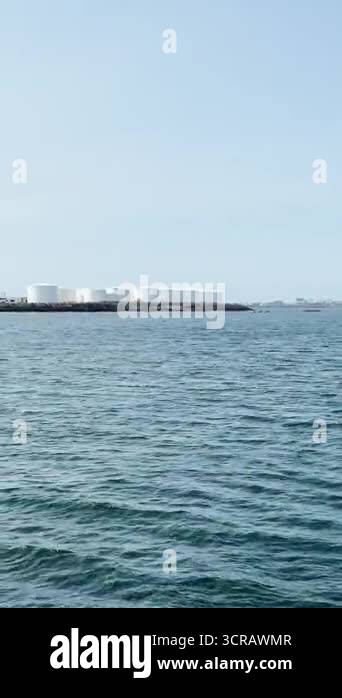 Vertical video, Northern Europe seascape, view of huge white tanks, oil ...