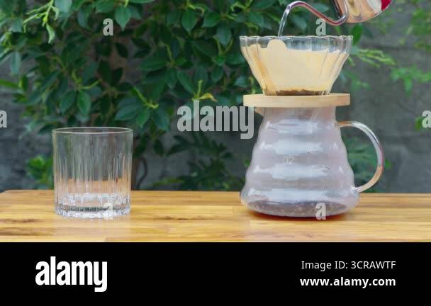 Drip French coffee brewing. Hand pouring hot water from kettle over ...