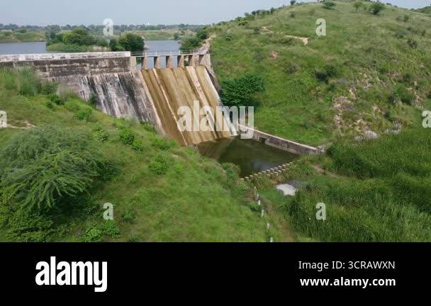 aerial drone view of small dam spillway with water stream flowing ...