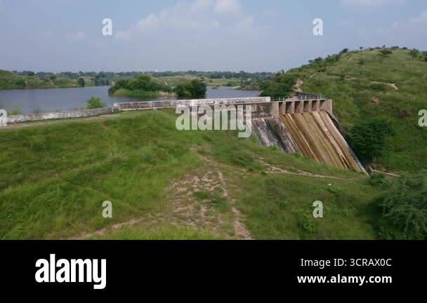 aerial drone view of small dam spillway with water stream flowing ...
