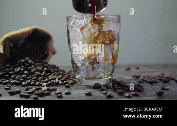 Pouring Brewed Coffee over Ice. Making iced black coffee. Cold brew ...