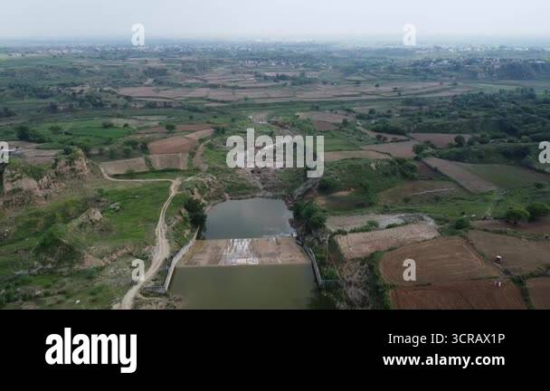 Village life with dam lake in the middle surrounded by farming fields ...