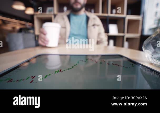 Young Man Using Tablet Computer and Looking at Screen with BTC Table ...