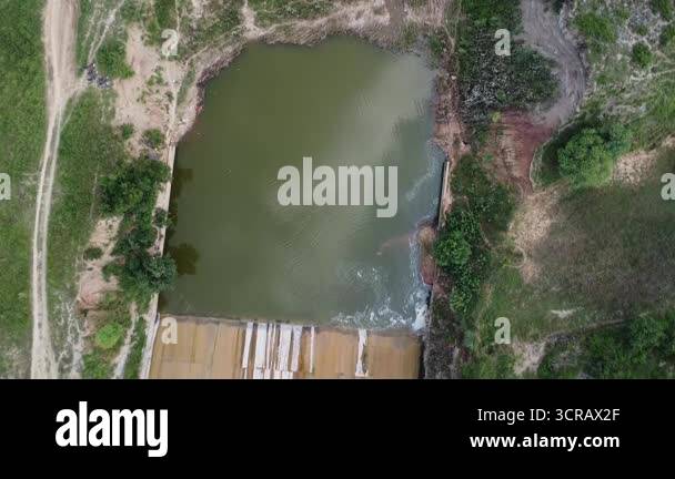 Tilt shot of small dam spillway releasing water flow showing hydraulic ...