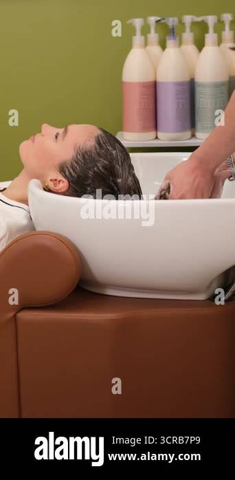 Female client sitting in salon chair with very long straight hair ...
