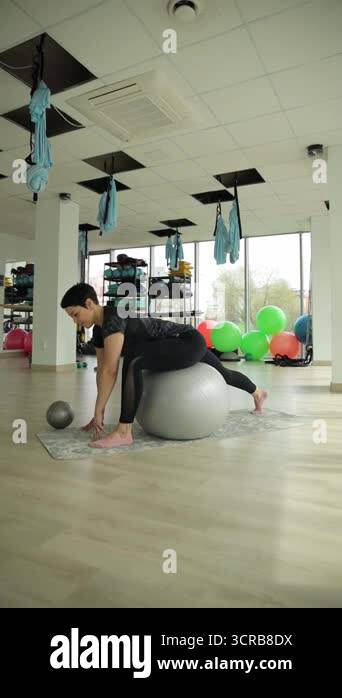 A person performs a workout routine using an exercise ball in a modern ...