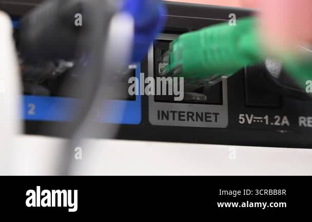 A woman pulls a cable out of an internet port on a router Stock Video ...
