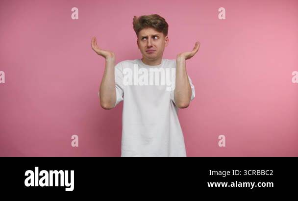 A person in a white shirt shows confusion with hand movements against a ...