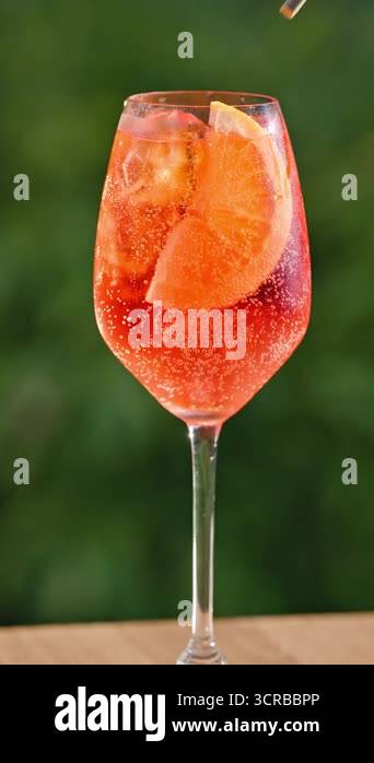 glass of fresh refreshing aperol spritz cocktail against a green ...