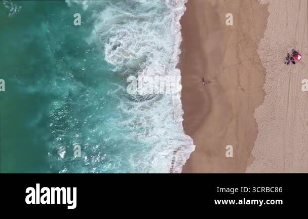 An expansive aerial view captures foamy ocean waves dramatically ...