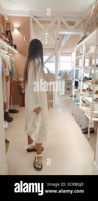 A model confidently showcases trendy outfits within a chic boutique ...