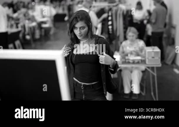 A fashion model showcases outfits in a vibrant setting, reflecting ...