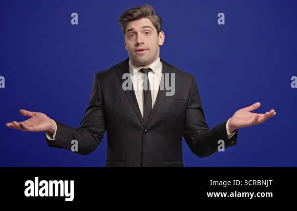 Man in formal clothes lifts shoulders and hands in I dont know gesture ...
