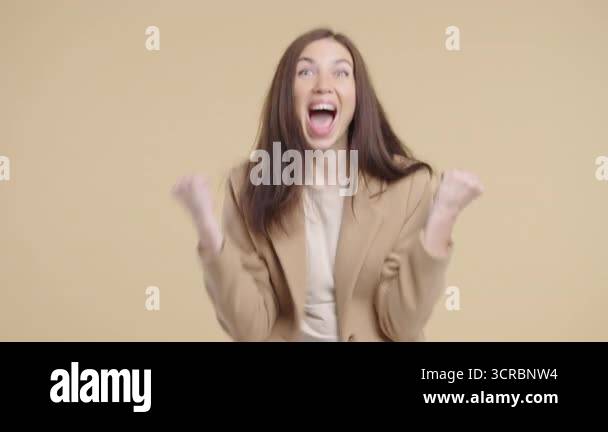 Confident brown-haired woman celebrates success with energetic fist ...