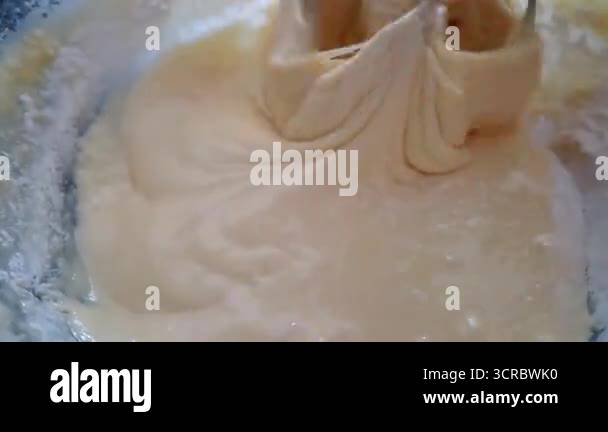 A close-up view of smooth, creamy batter being mixed, showcasing ...