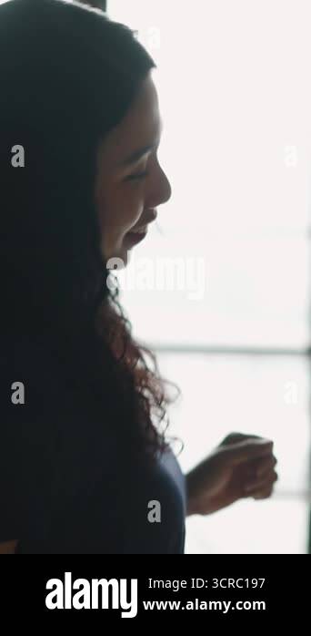 Woman posing, smiling softly beside bright window frame - 4K Horizontal ...