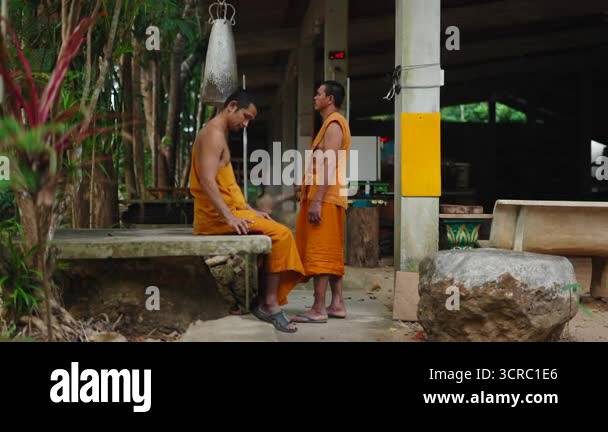 At Khao Phang Monastery in Thailand monks strike a bell with a wooden ...