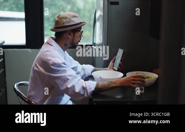 Professional chef video calling during lunch break in modern restaurant ...