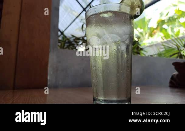 Fresh lime with ice cubes in a glass, refreshing citrus drink perfect ...