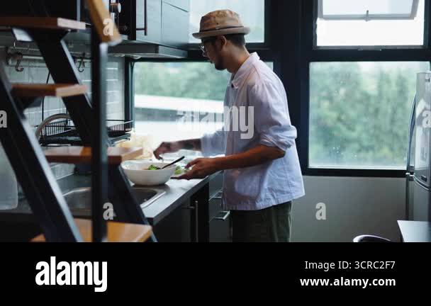 Professional chef meticulously prepares fresh ingredients in a stylish ...