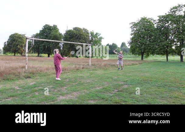 Two players closely watch the shuttlecock during a badminton game on a ...