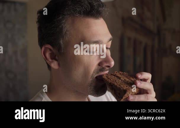 Man enjoys a slice of rich chocolate cake, showcasing joy and ...