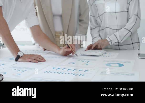 Professional team reviewing financial data, collaborating on charts and ...